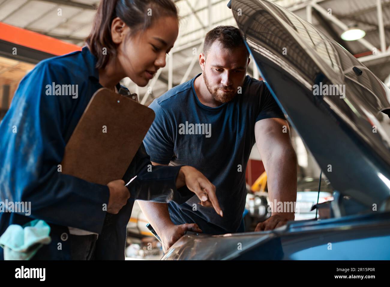 Our troubleshooting means no trouble for you. two mechanics working together on a car in an auto ...