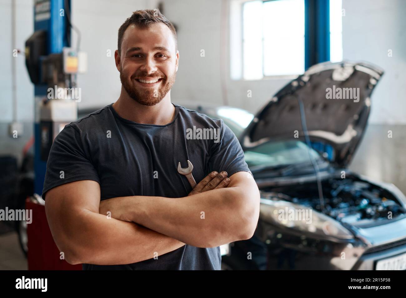 I opened up my own garage and its doing well. a mechanic posing with ...