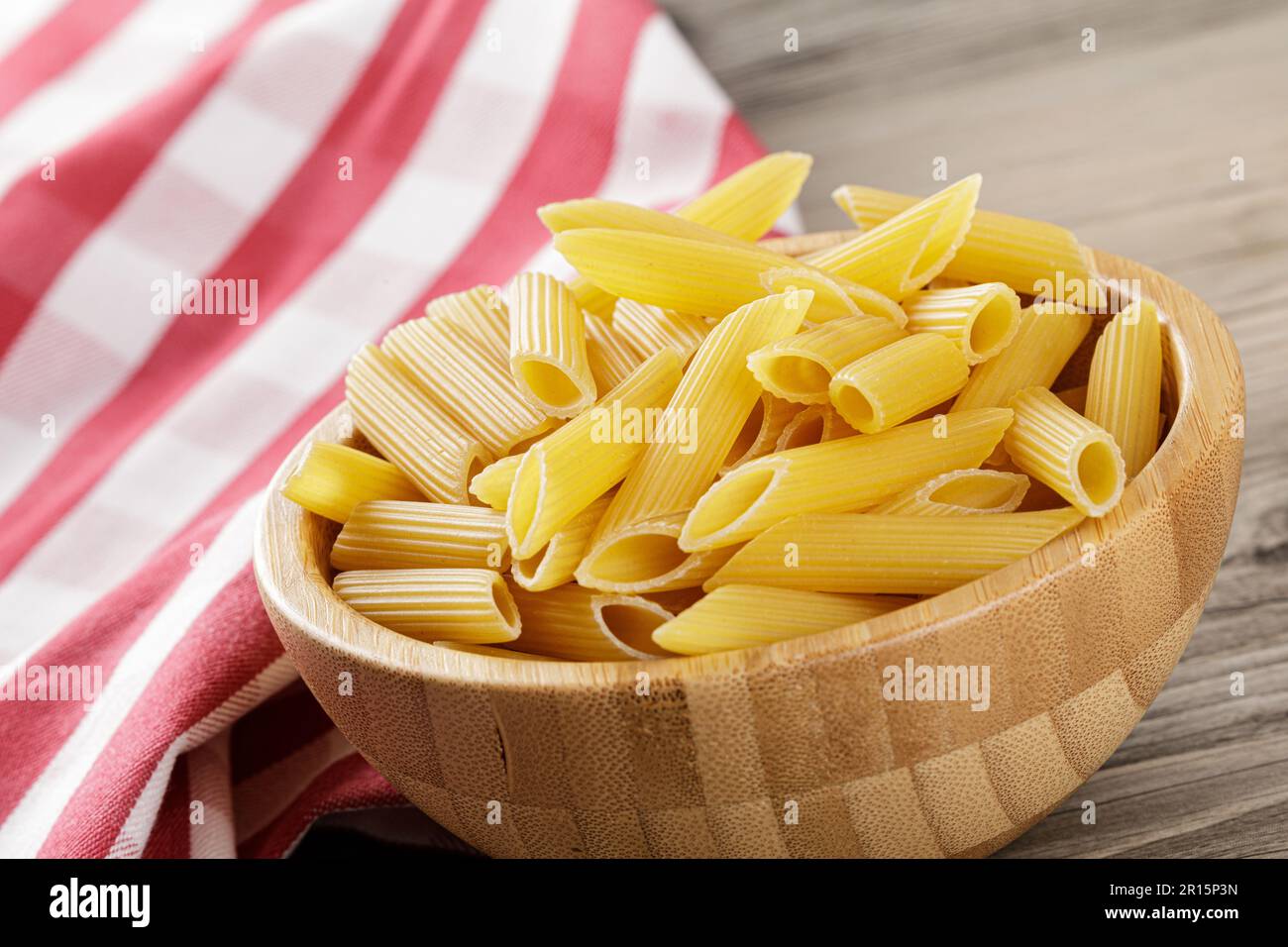 Raw Penne Rigate noodles isolated on a gray wooden background Stock ...