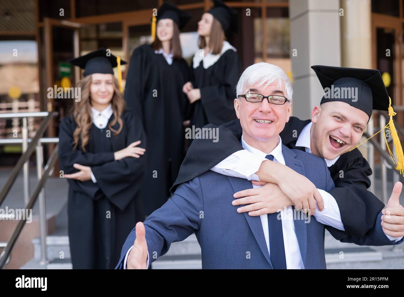 Father and son embrace at graduation. Parent congratulates university ...