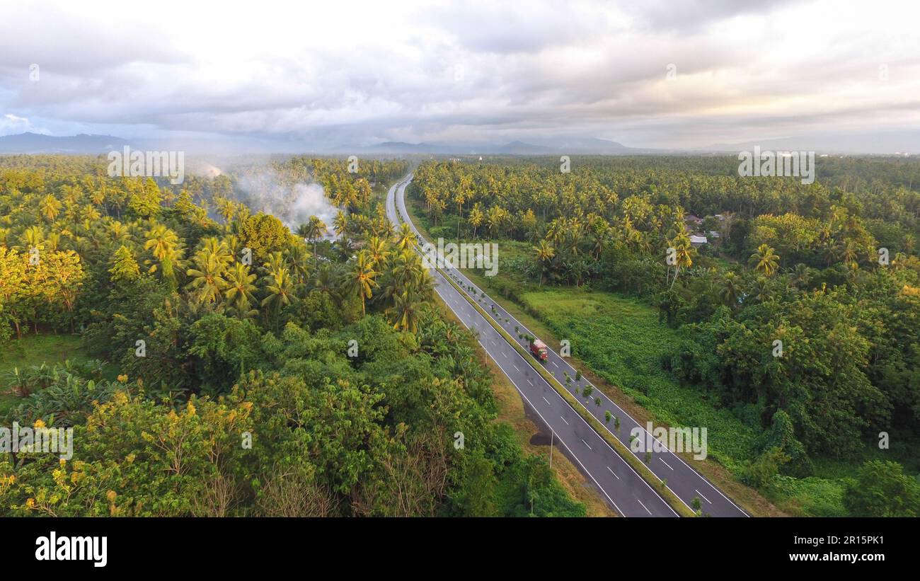 Aerial photo of the highway dividing the forest and villages with a ...