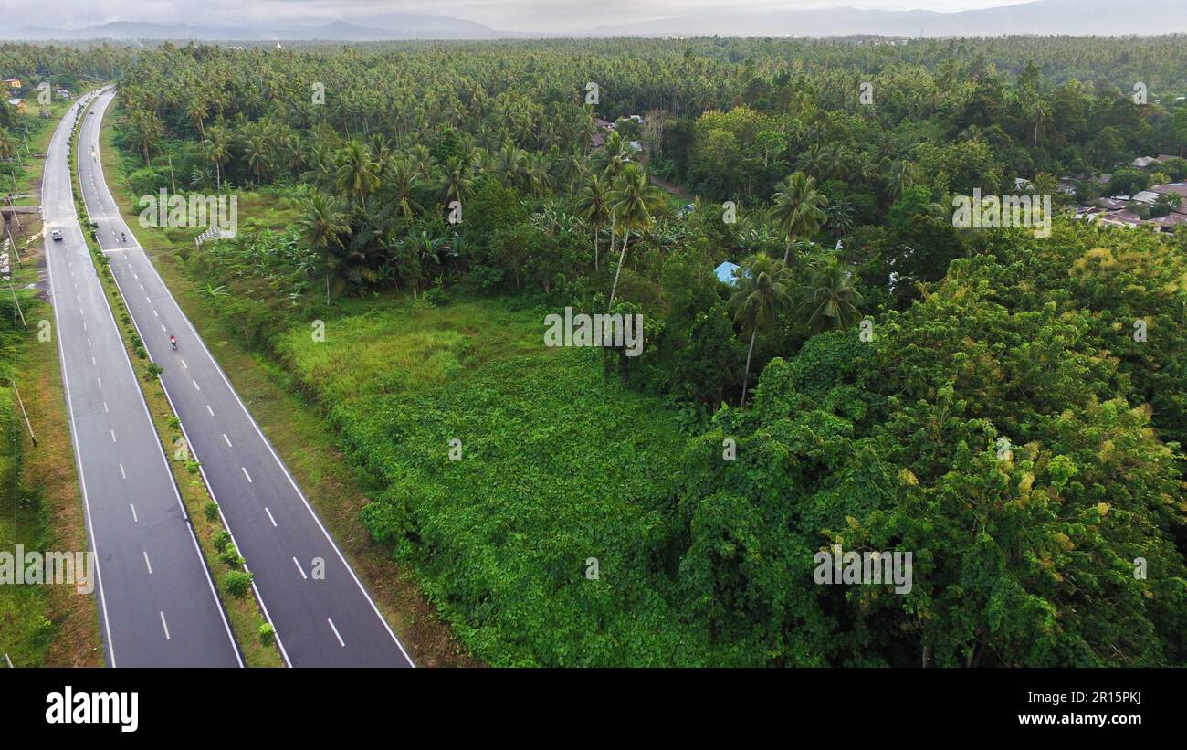 Aerial photo of the highway dividing the forest and villages with a ...