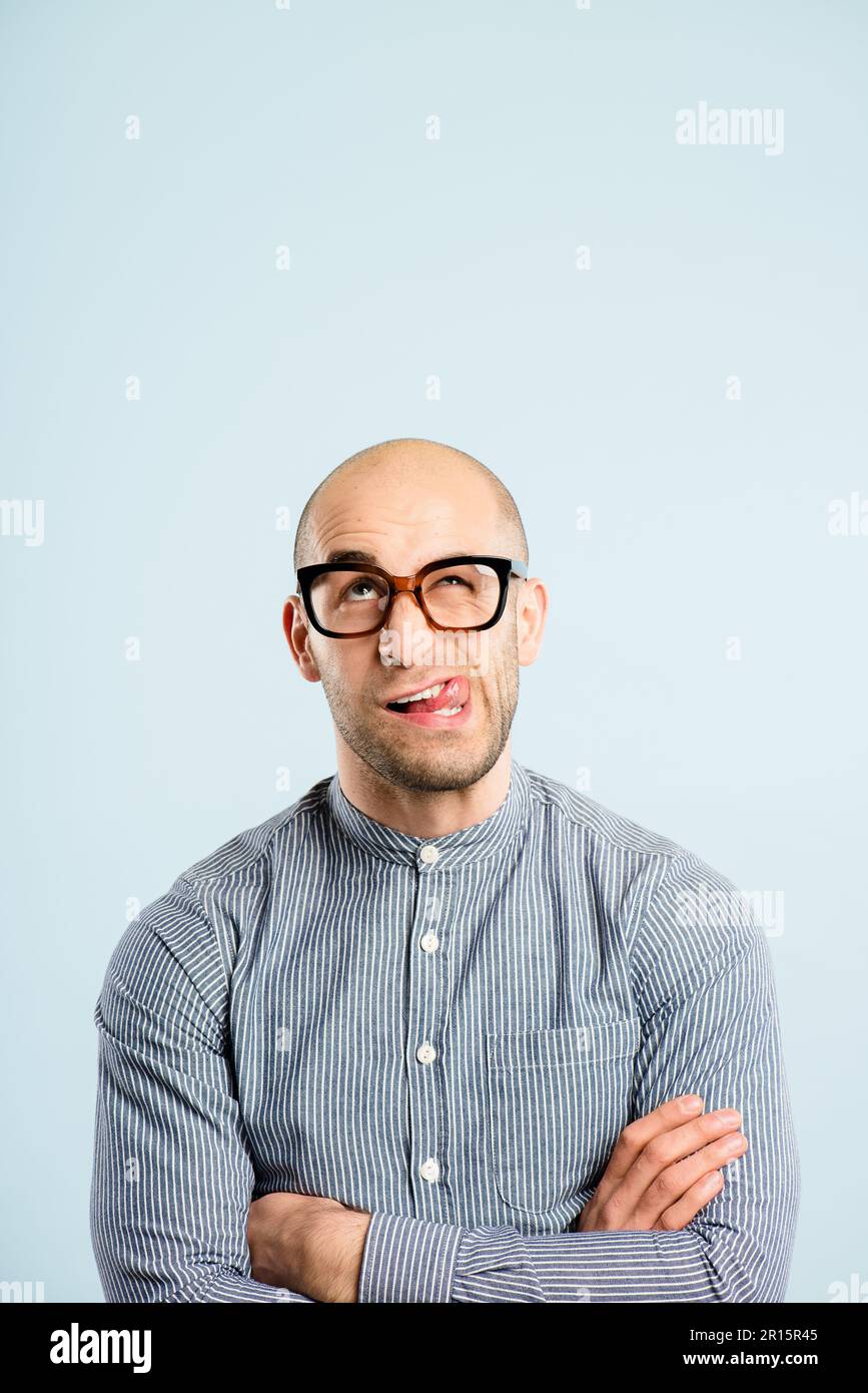 I dont feel like being goofy. a handsome young man sitting alone in the ...