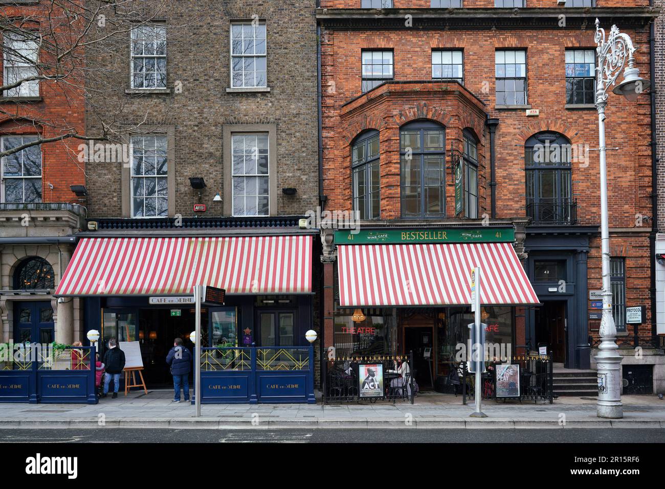 Cafes with outdoor seating and colorful striped awnings on Dawson ...