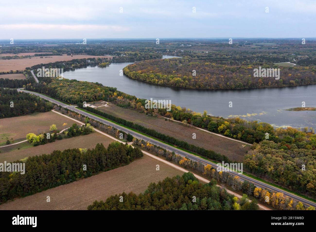 River Meanders Through Forest Past Trail Road and Farms - drone aerial ...