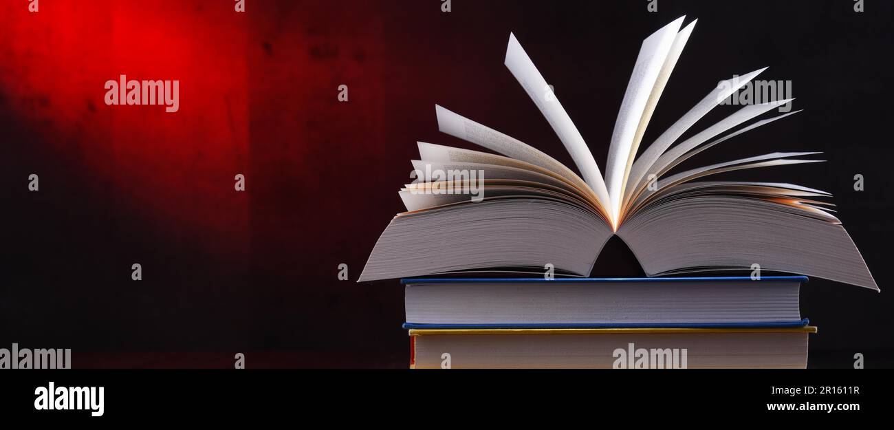 Composition with open book on the table Stock Photo - Alamy
