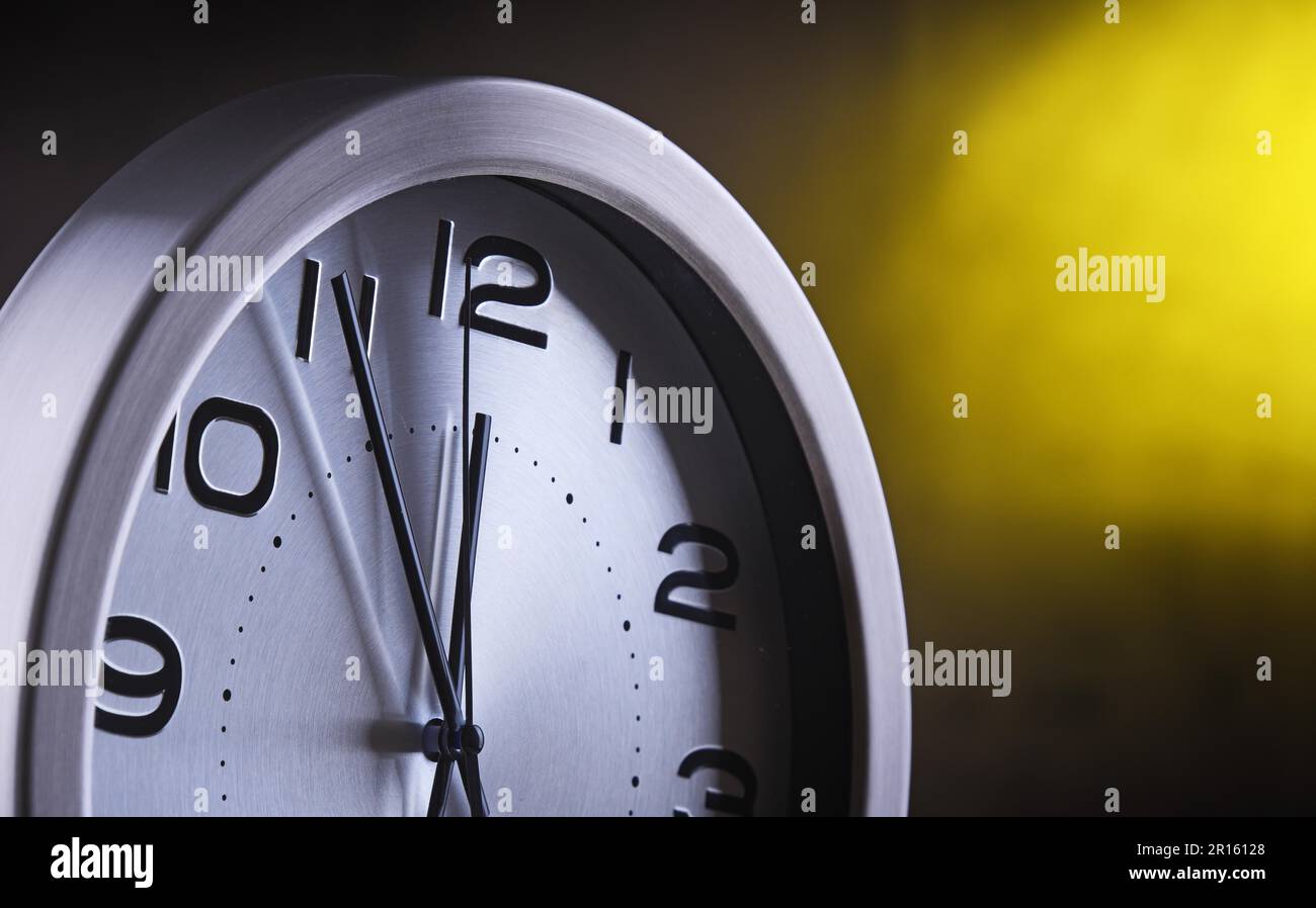 Modern wall clock showing five to twelve Stock Photo - Alamy