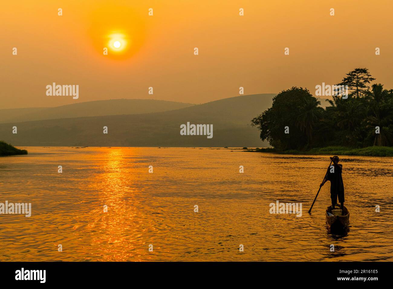 Man on his dugout canoe at sunset on the Congo river, DR Congo Stock ...