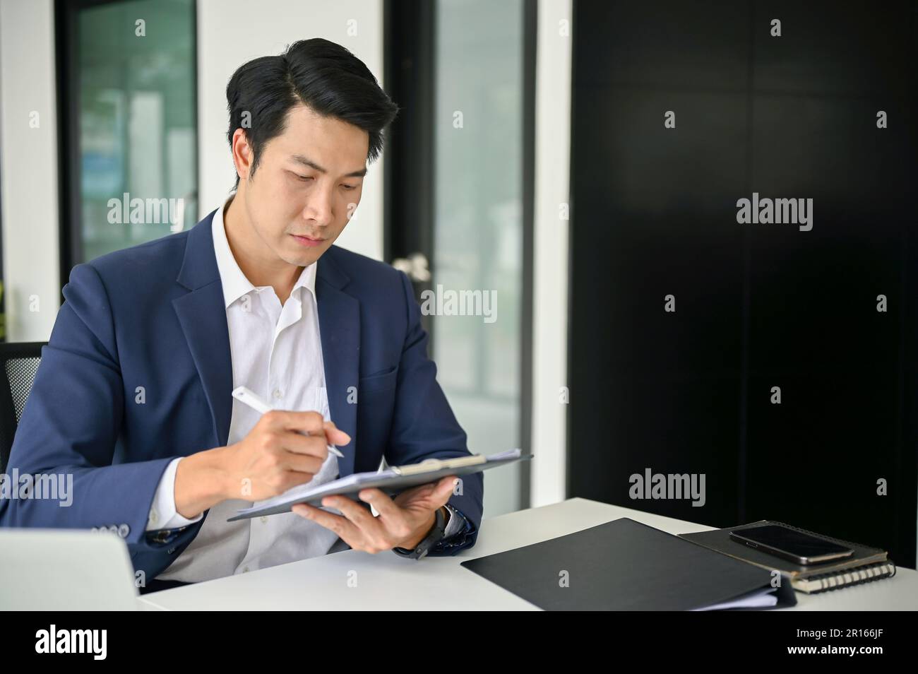Smart millennial Asian businessman focuses on rechecking business ...