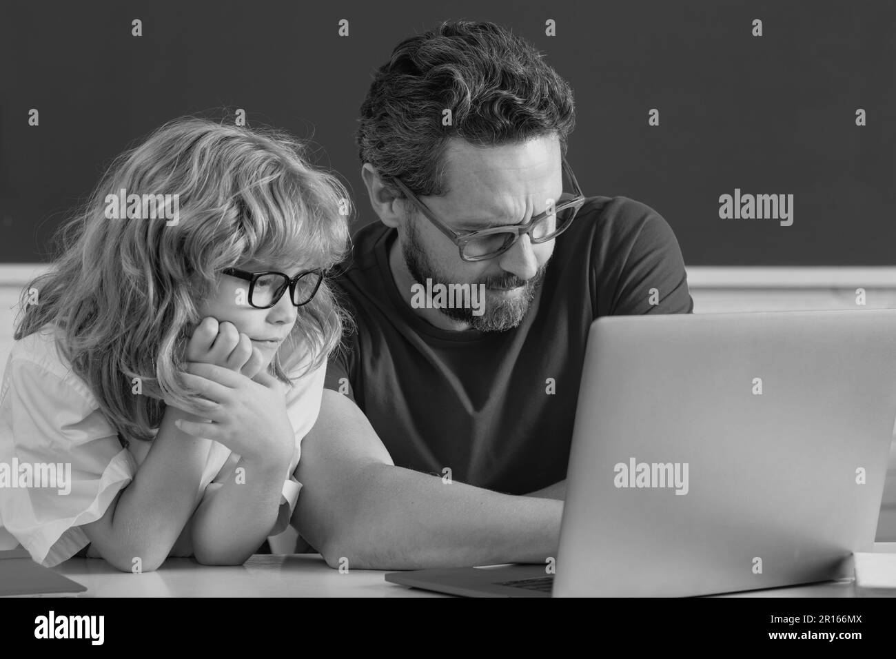 School teacher and child pupil learning at laptop computer, studying ...