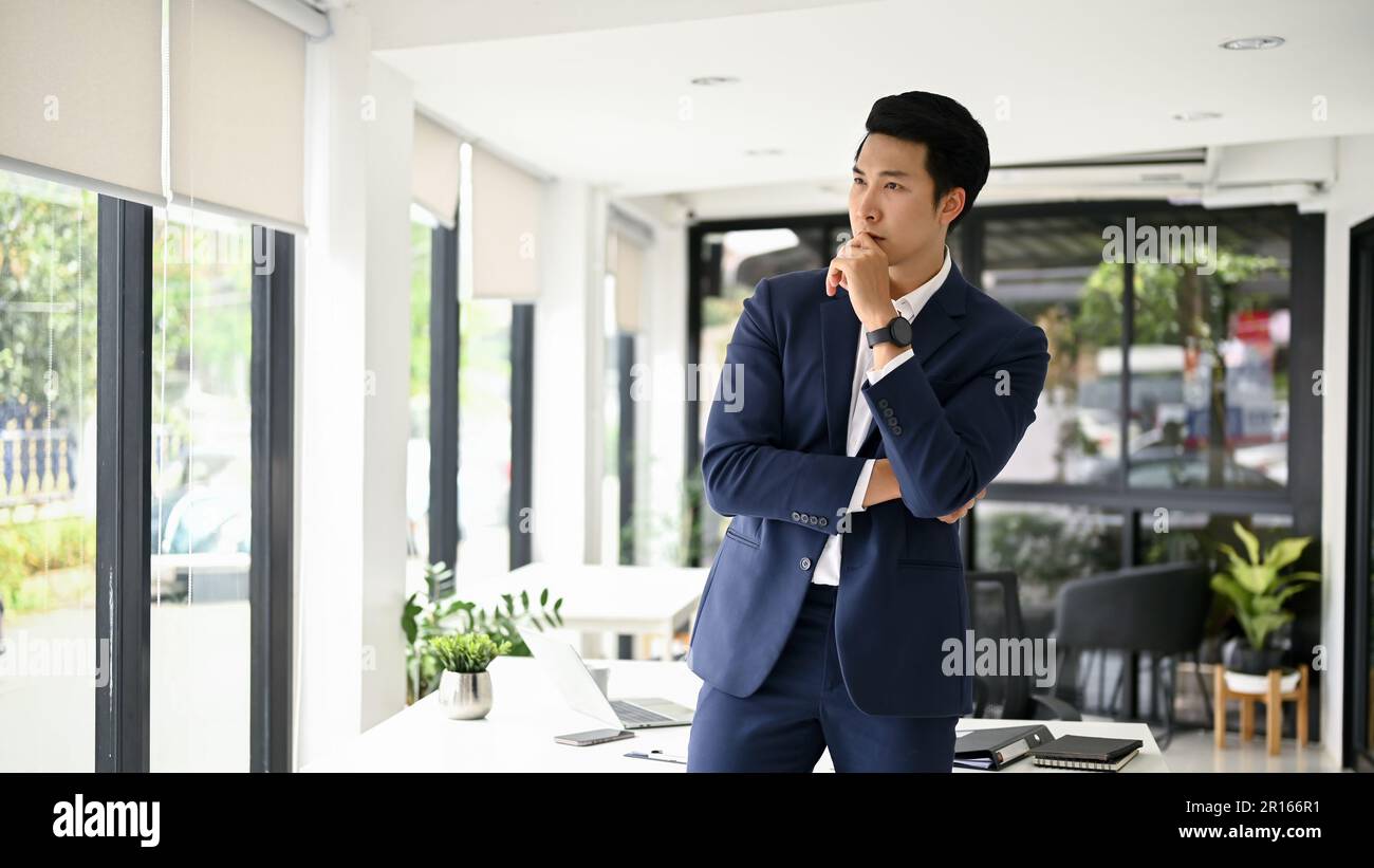 Thoughtful and professional millennial Asian businessman in formal ...