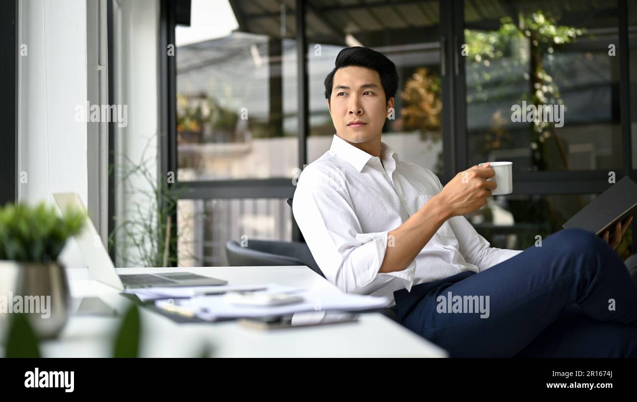 Successful and inspired millennial Asian businessman or male CEO ...