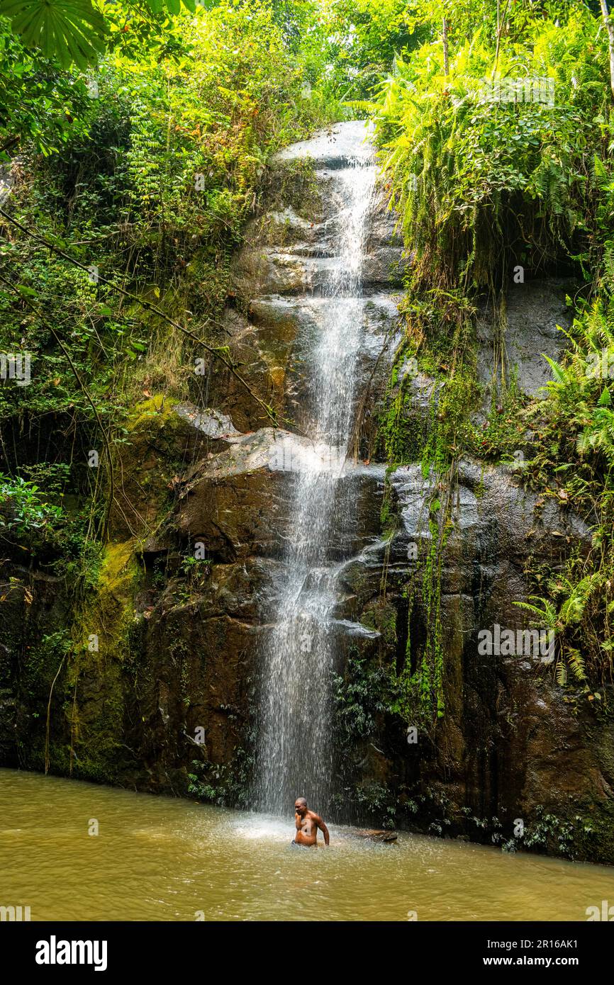 Man taking a bath under a small waterfall near the Zongo waterfall, DR ...