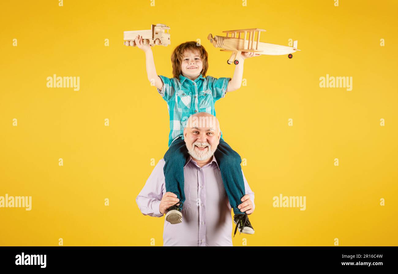 Child boy and grandfather playing piggyback ride with plane and wooden ...