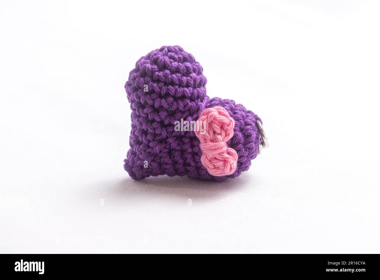 A single crocheted purple heart-shaped keyring on a white background ...