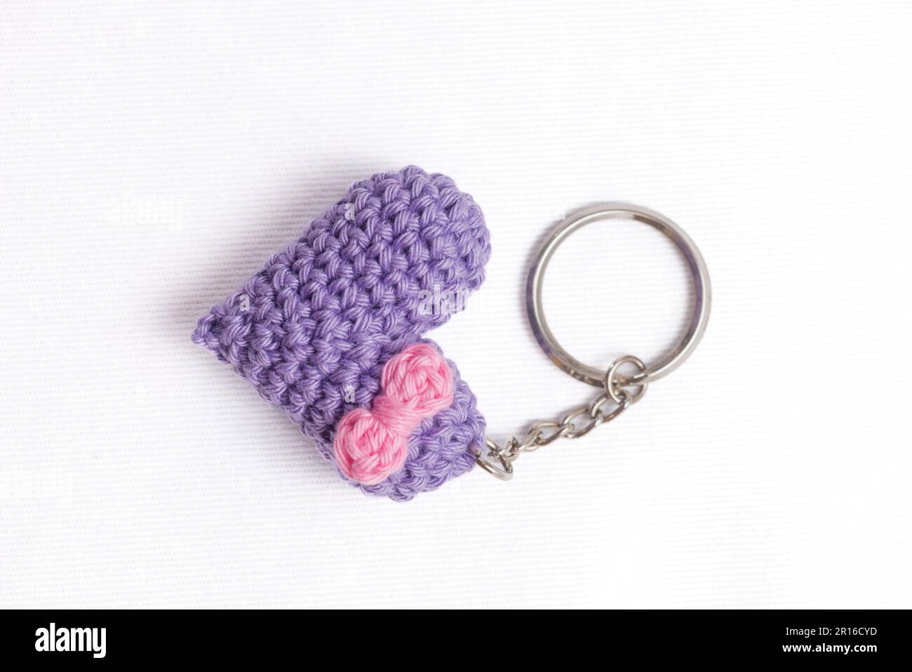 A single crocheted purple heart-shaped keyring on a white background ...