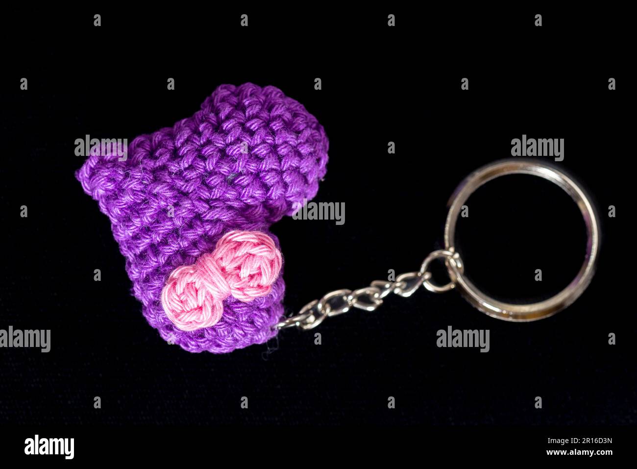 crocheted purple heart-shaped keyrings on a black background Stock ...