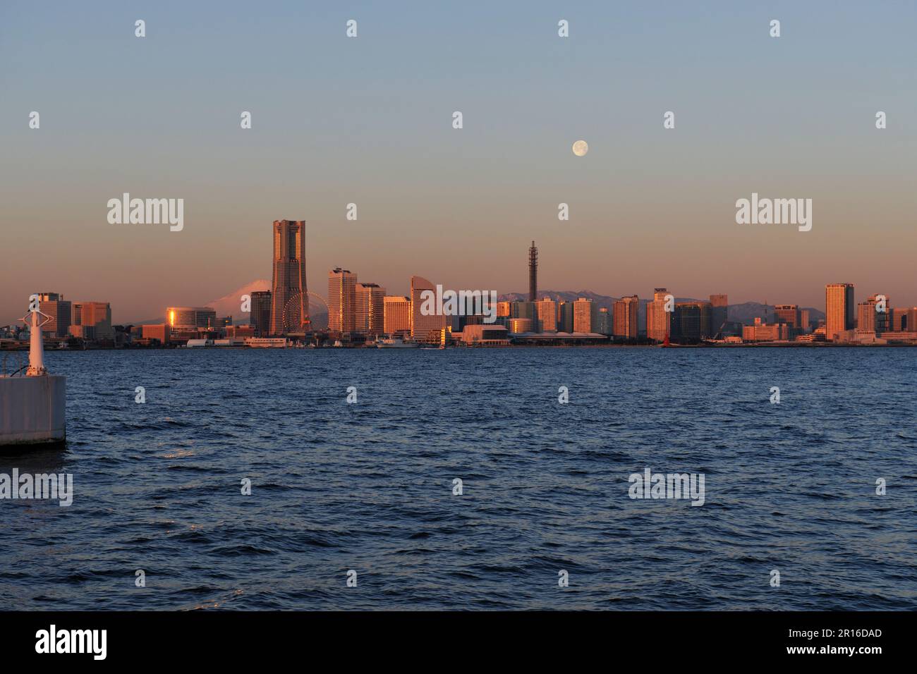 Full moon and buildings of the Minato Mirai shining in the morning sun ...