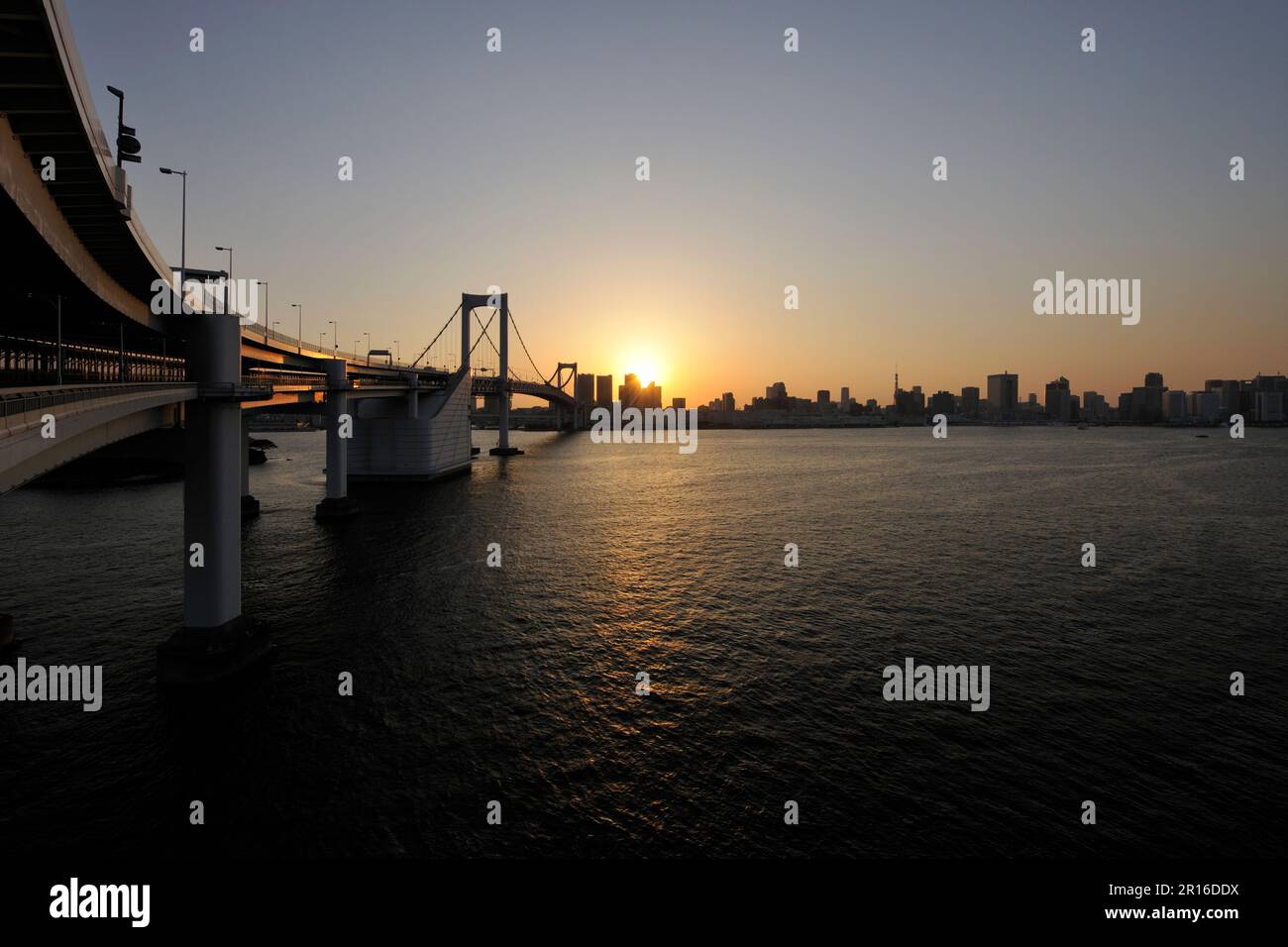 Sunset at the Tokyo port and Rainbow Bridge and waterfront buildings ...