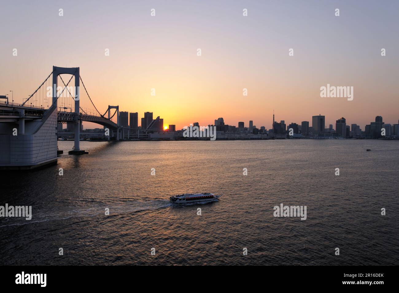 Sunset at the Tokyo port and Rainbow Bridge and waterfront buildings ...