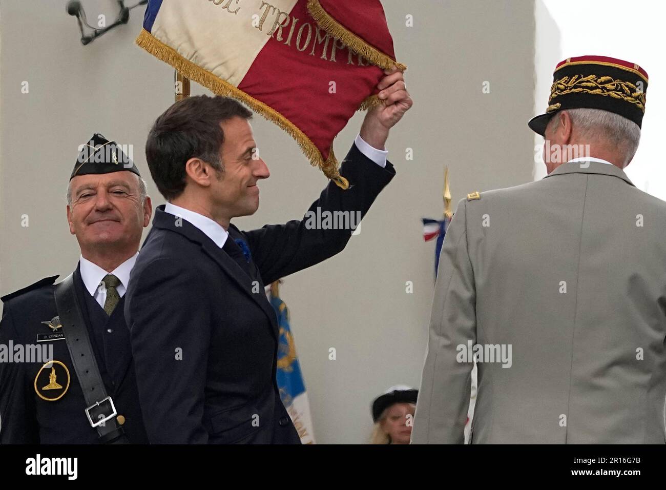 French President Emmanuel Macron touches the national flag at the tomb ...