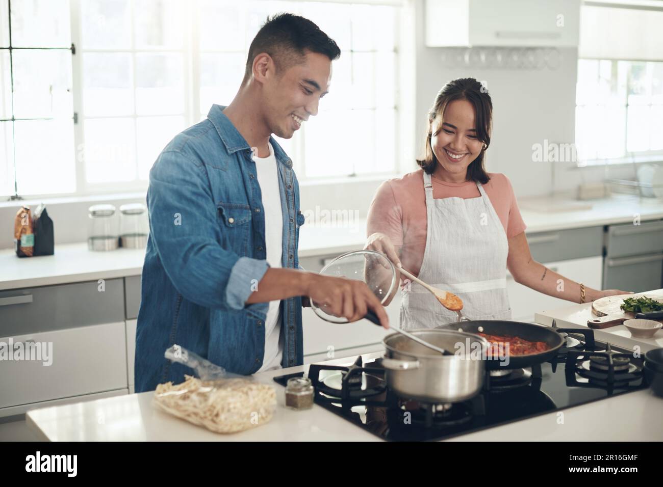 Cooking together is quality time too. a young couple cooking together ...