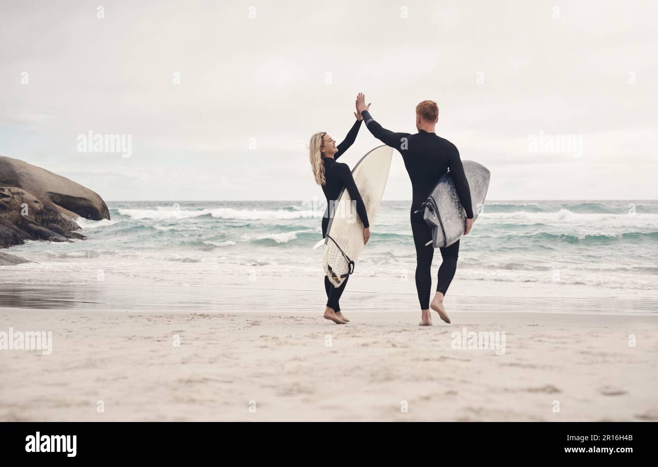 Lets go catch some waves, babe. a couple giving each other a high five ...