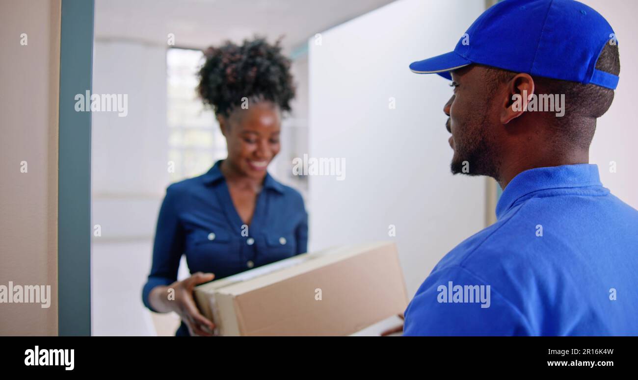 Happy Young Woman Accepting Cardboard Box From Delivery Man Stock Photo ...