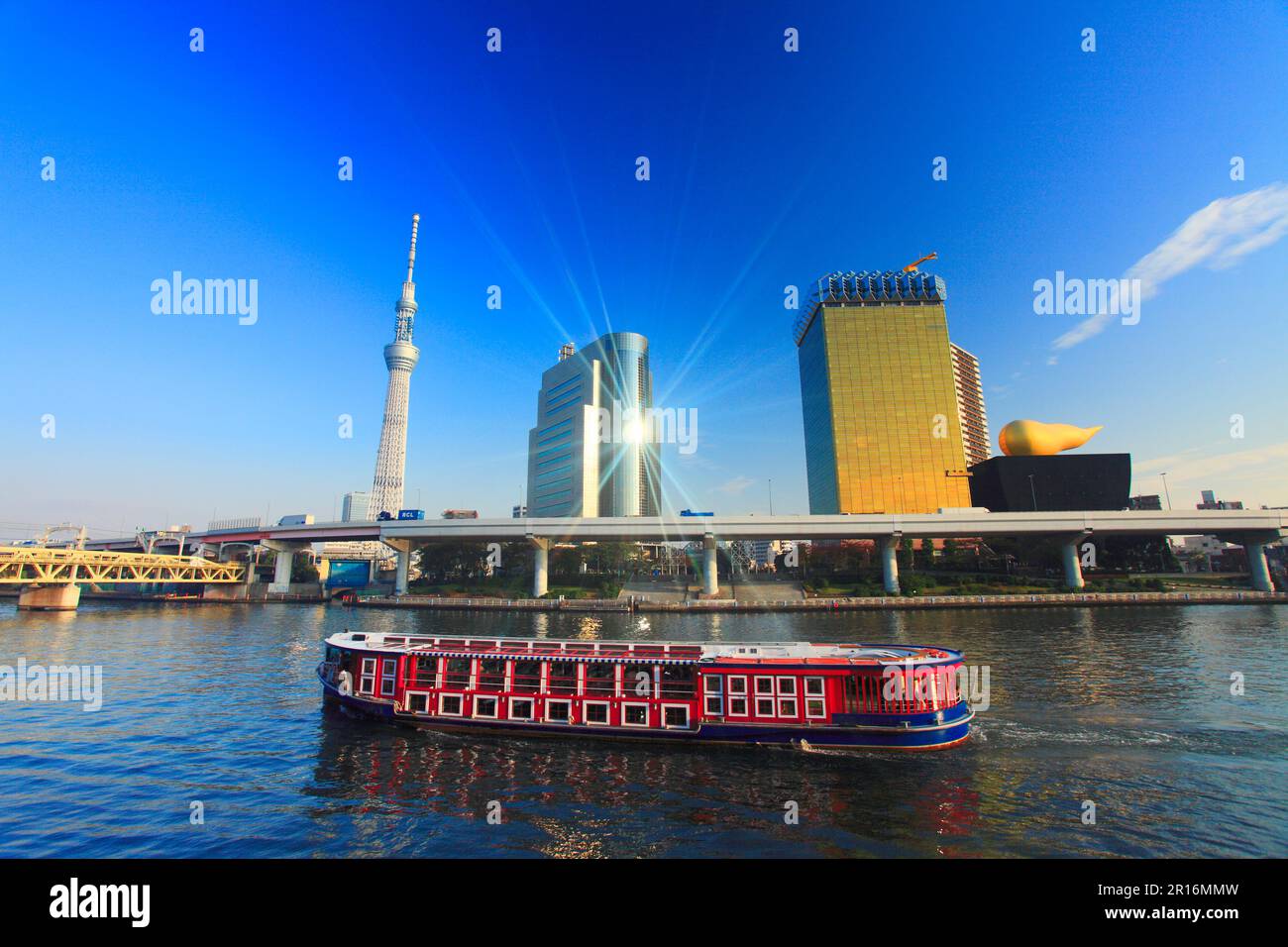 Tokyo Sky Tree and glistening Sumida ward offices and a tourist boat ...