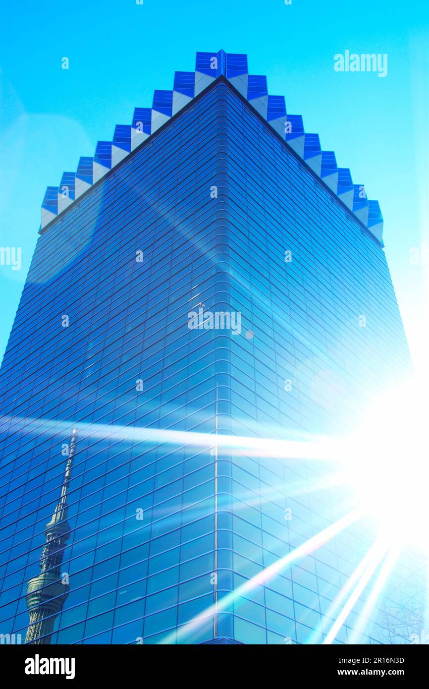 Glow of the sun and Tokyo Sky Tree reflected in the glass wall of the ...