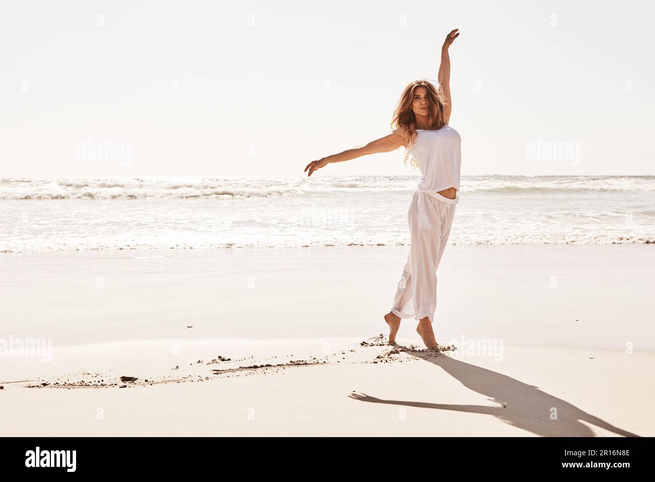 Nature makes me feel so alive. a young woman standing with her arms ...