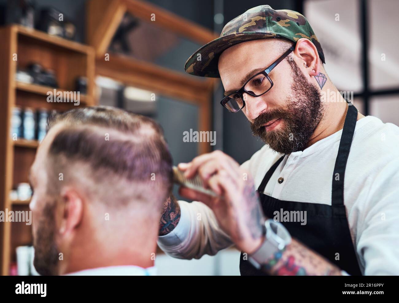 He turns every hairstyle into a masterpiece. a handsome young barber ...