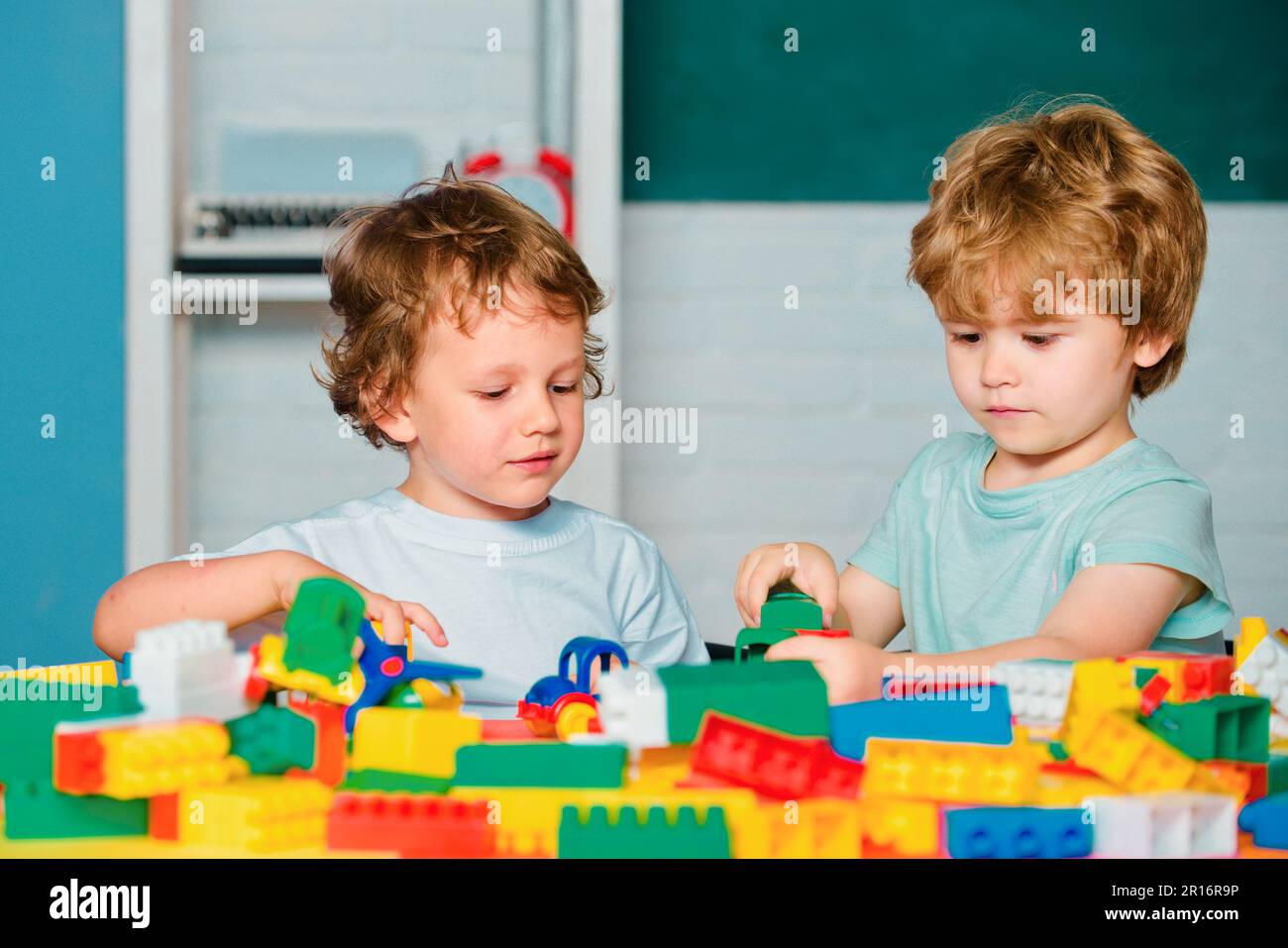Happy cute clever boy pupils. Toddler children friends play with blocks ...