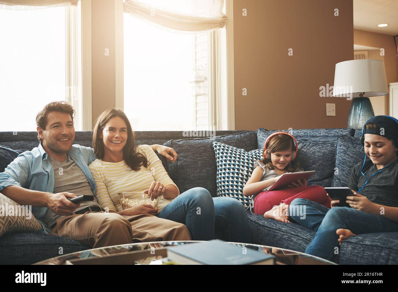 Technology, happy family together and in living room of their home with ...