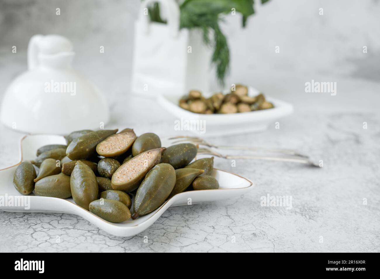 capers in white dishes on a light background. Pickled capers. Canned ...