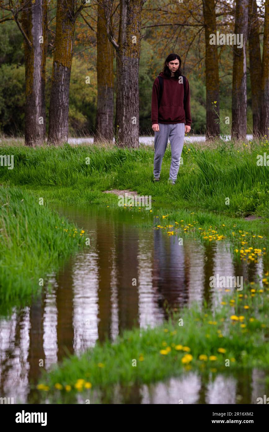 man long brunette hair brown sweater gray pants Mud large puddle rural ...