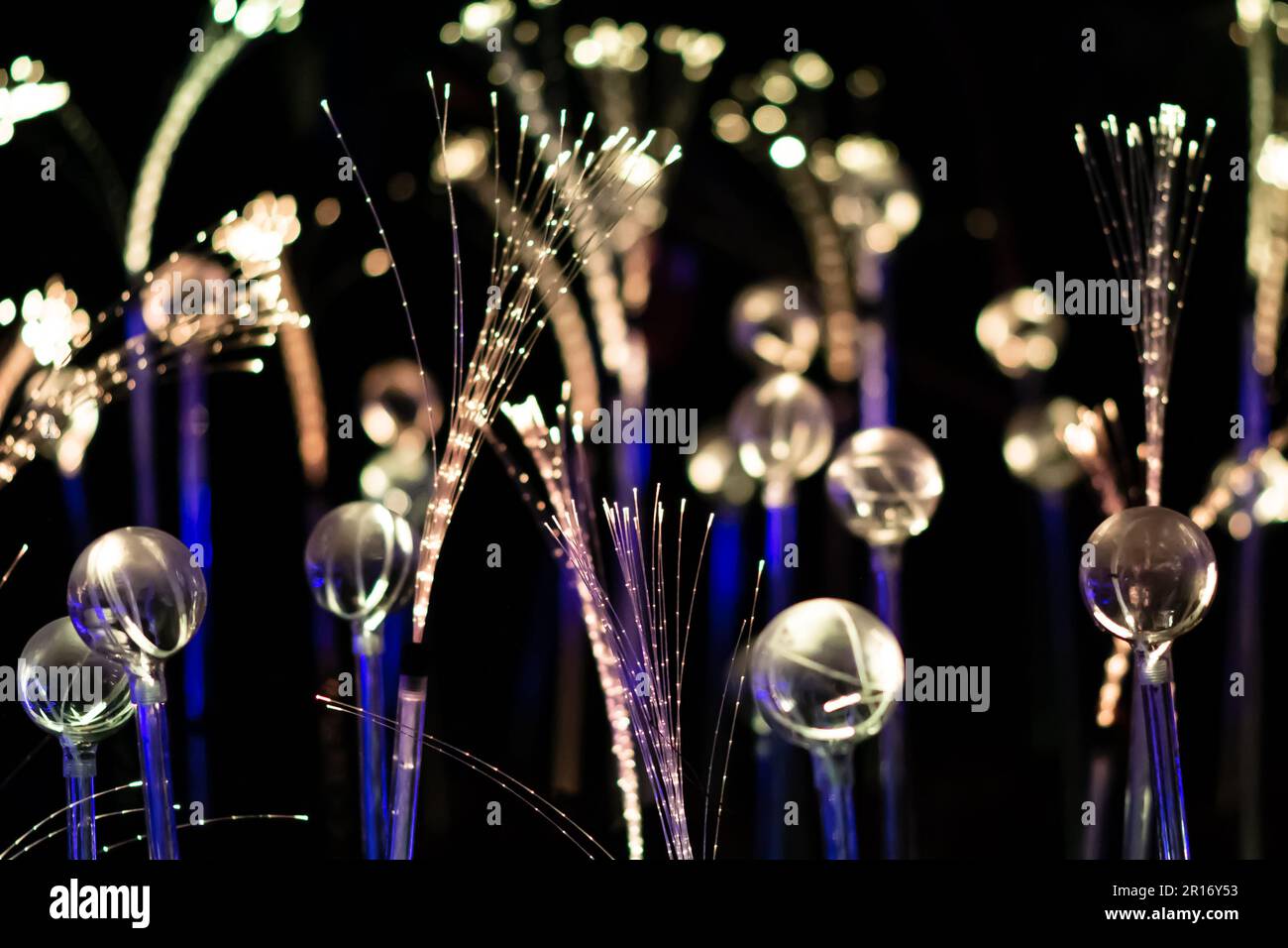 White, golden yellow and blue fiber optic strands or filaments creating ...