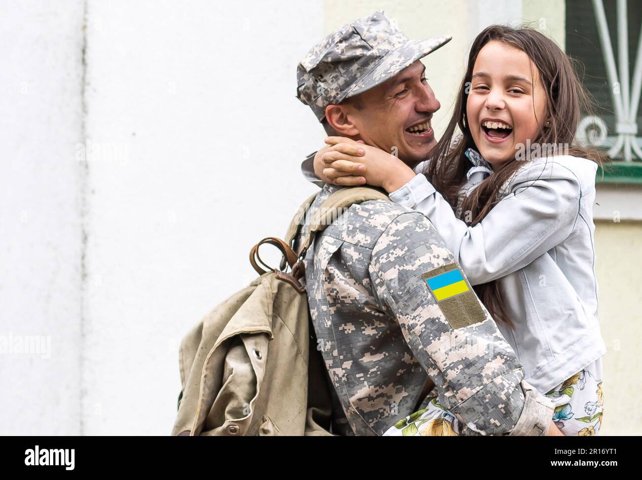 Father in Ukrainian military uniform and his daughter. Family reunion ...