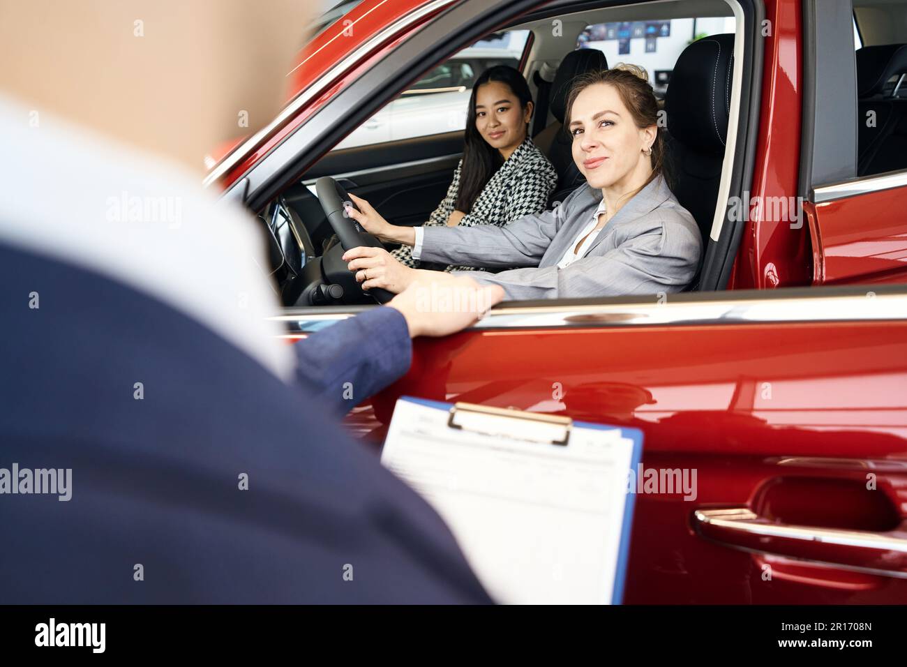 Women red car showroom hi-res stock photography and images - Alamy