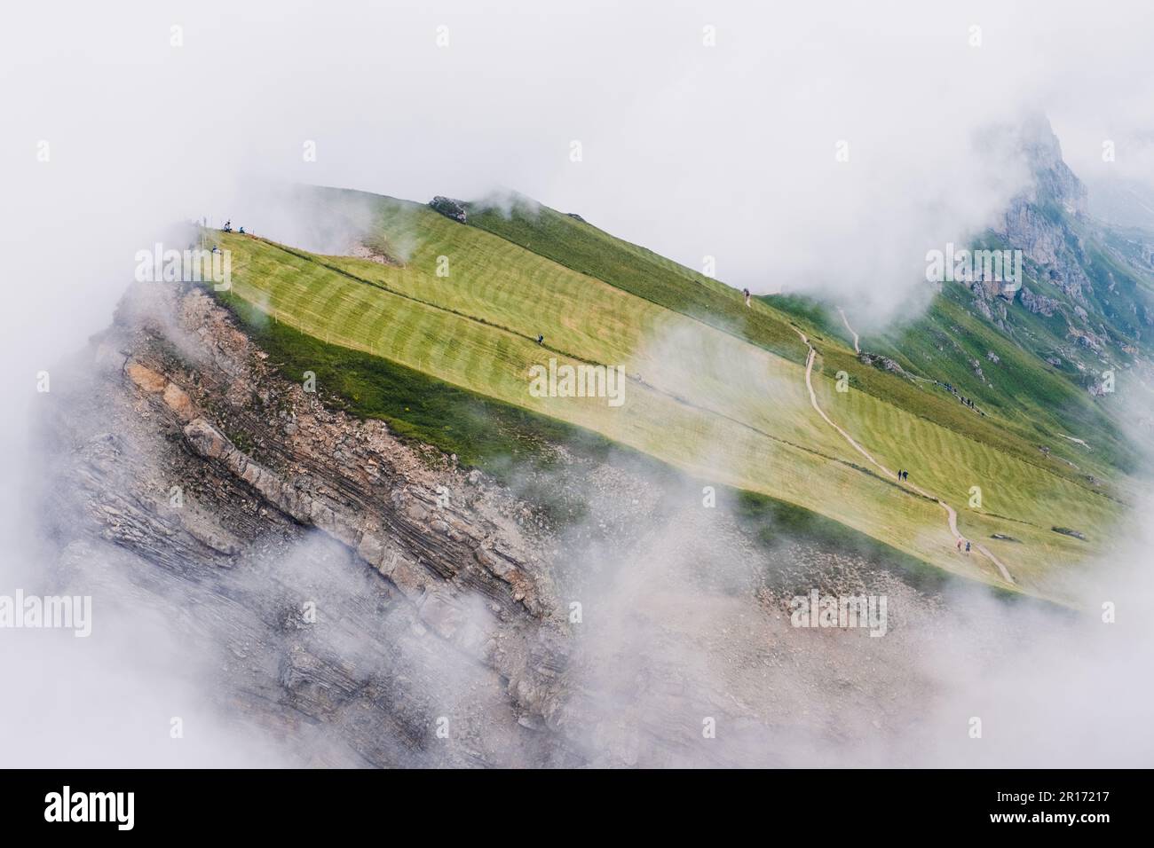 Mount Seceda in the Dolemites during a beautiful foggy morning. Iconic ...