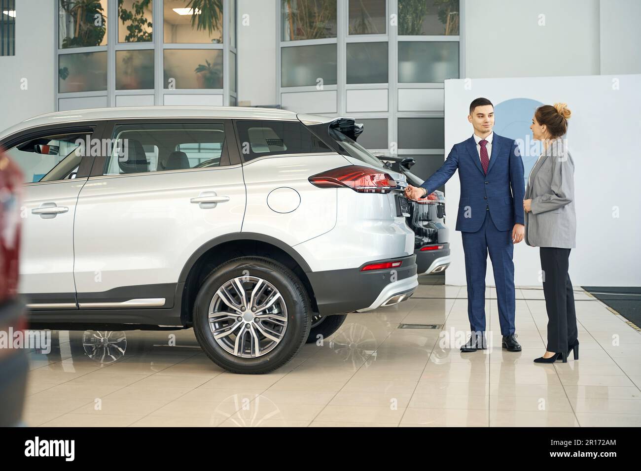 Man in suit demonstrate white crossover to happy lady Stock Photo - Alamy