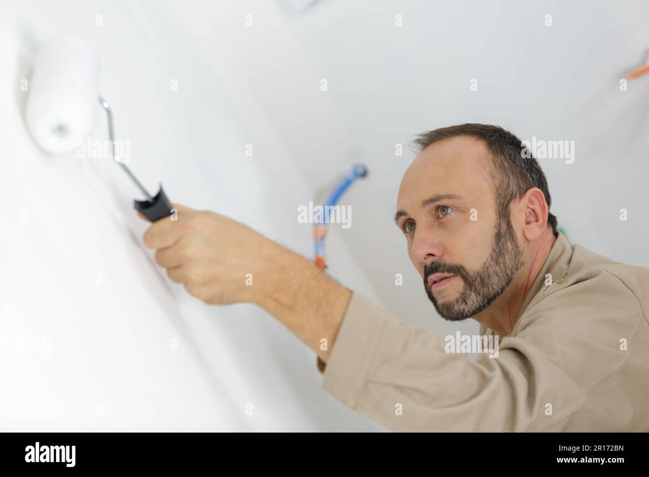 professional male painter using roller Stock Photo - Alamy