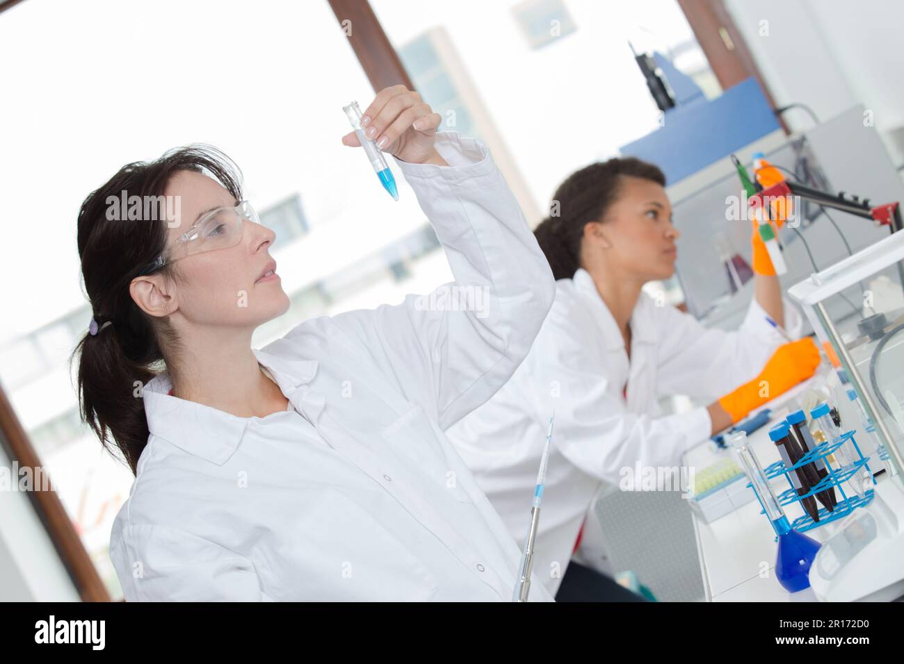 beautiful female lab worker holding up test tube Stock Photo - Alamy