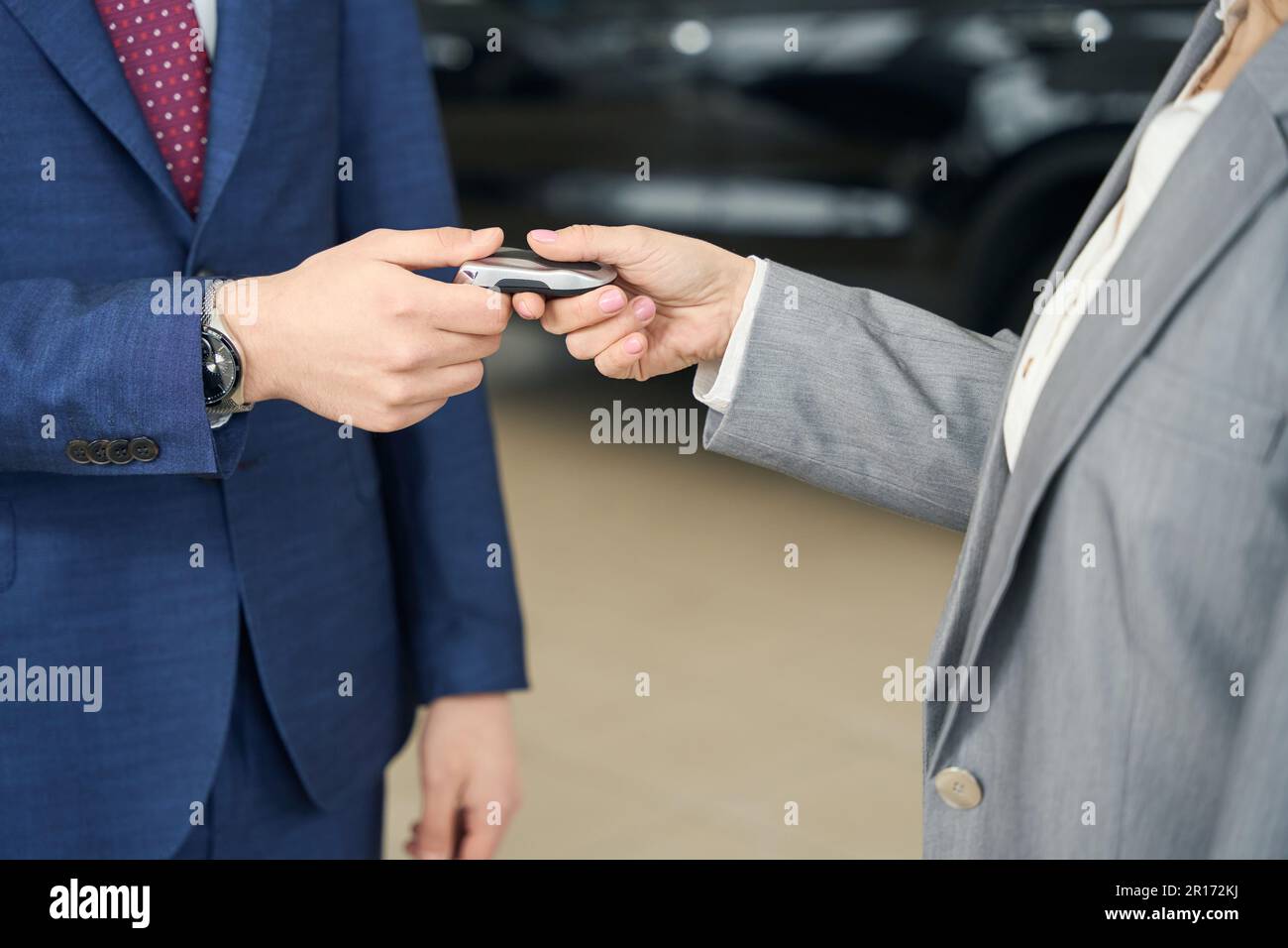 Business people in suits holding car key in hands Stock Photo - Alamy