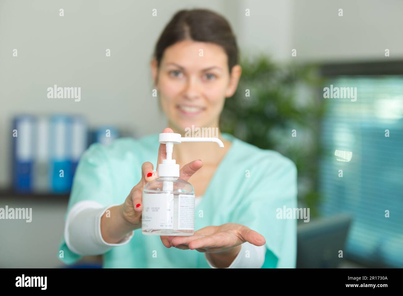 female nurse showing a gel pushing pump bottle Stock Photo - Alamy