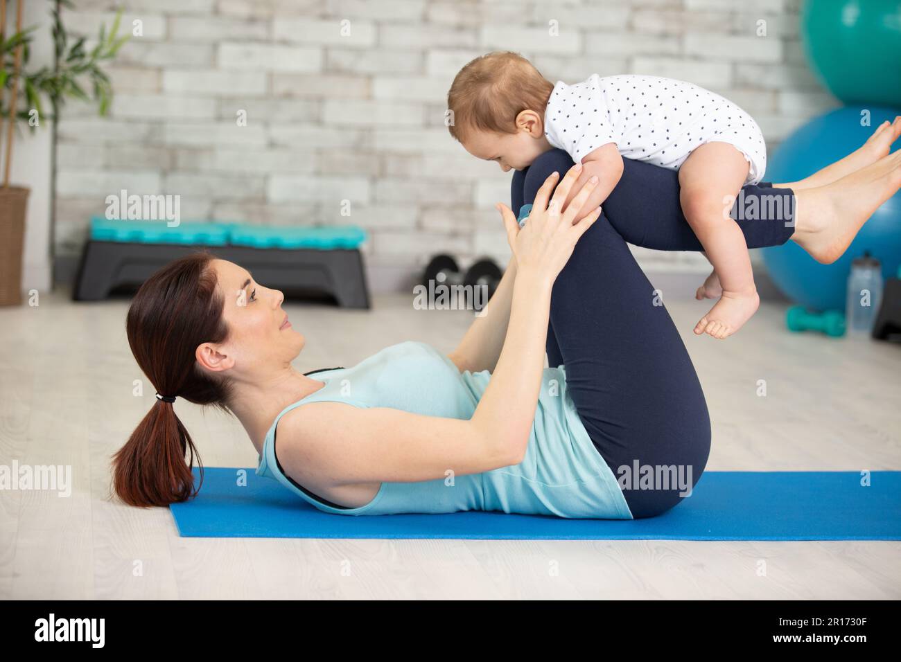 young mother does physical fitness exercises with her baby Stock Photo ...