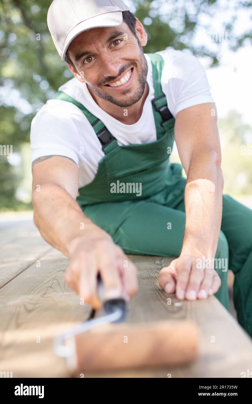 happy handsome handyman renovating terrace Stock Photo - Alamy