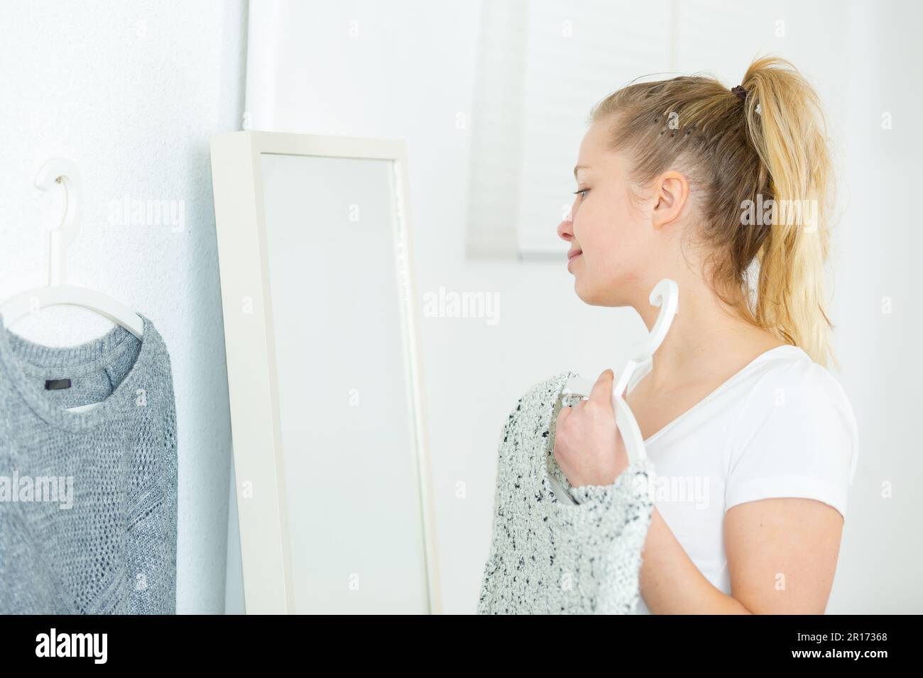 beautiful young woman trying on clothes in the shop Stock Photo - Alamy