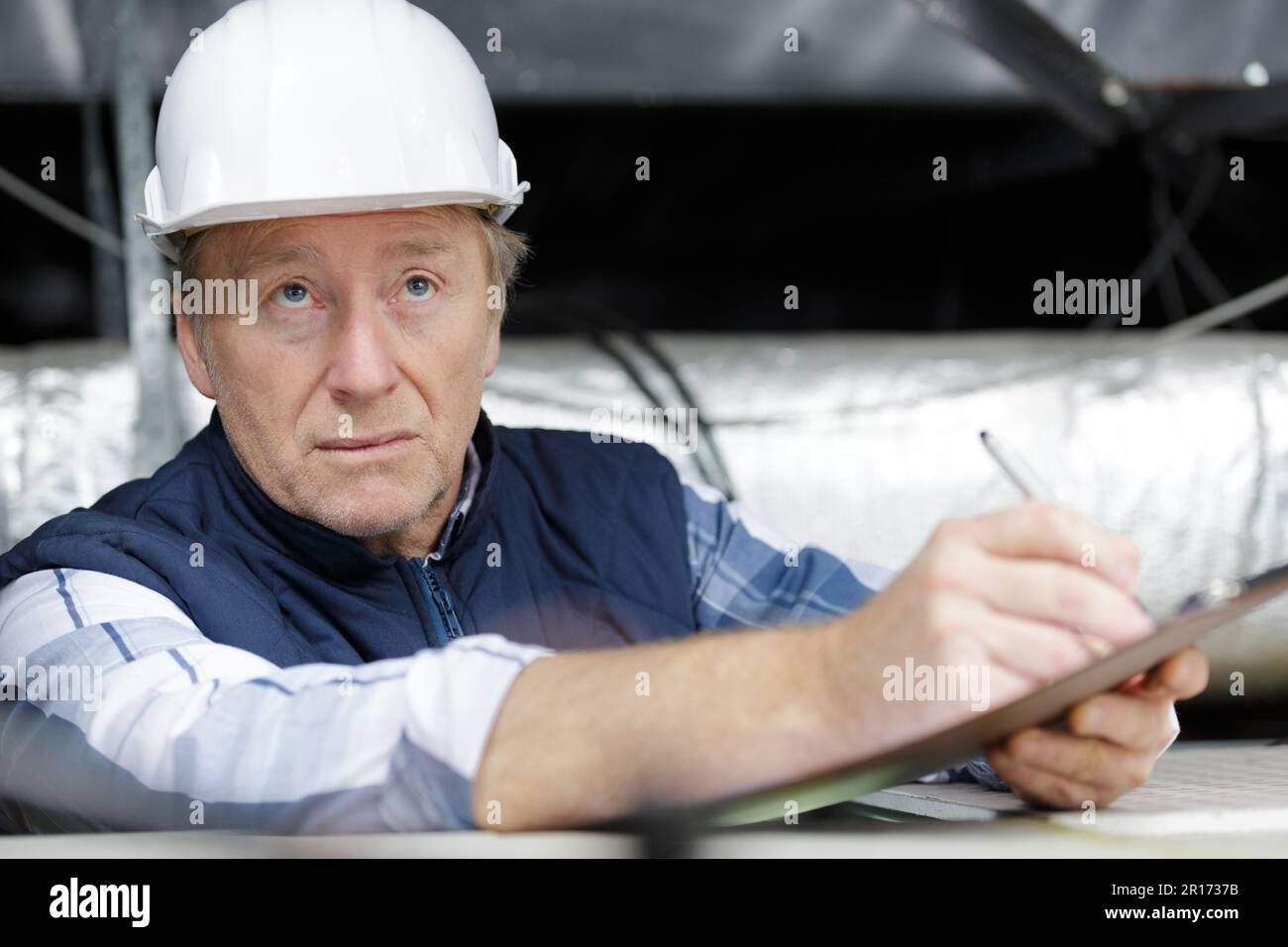 man electrician wiring inside ceiling taking notes Stock Photo - Alamy