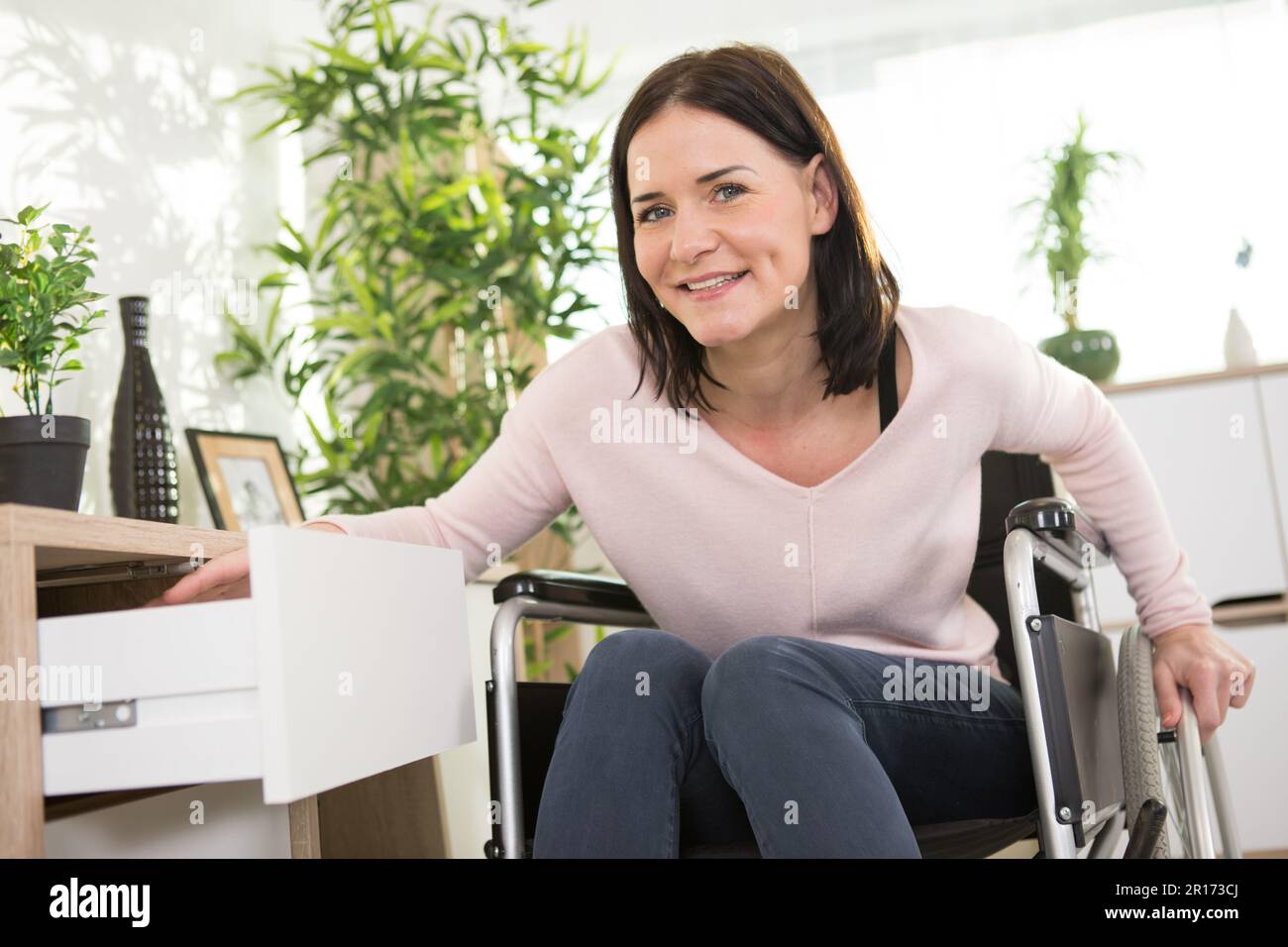 young disabled woman in wheelchair opens drawer Stock Photo - Alamy